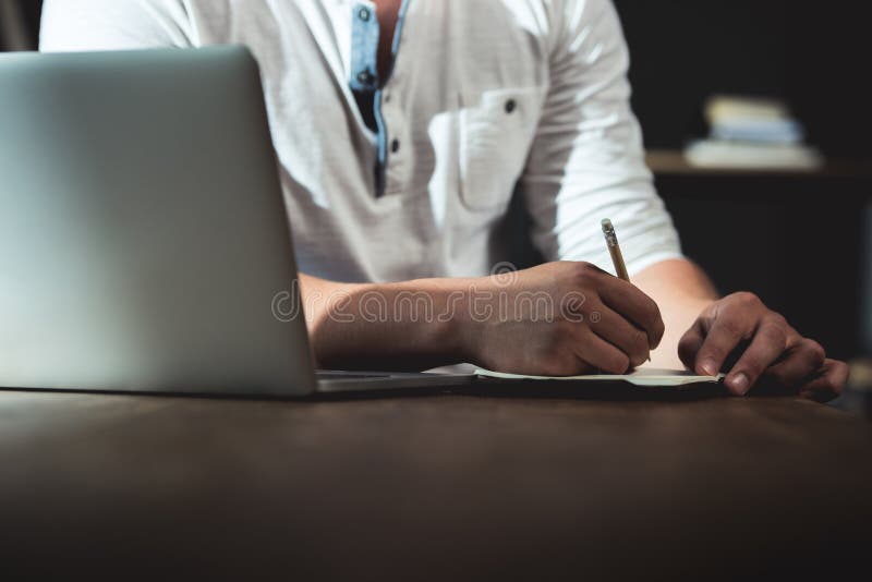 Man Writing in Notebook during Work while Sitting at the Table with ...