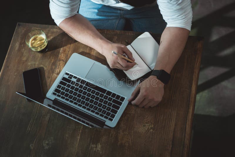 Man Writing in Notebook during Work while Sitting at the Table with ...