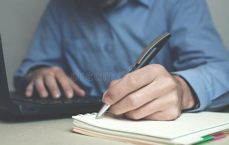 Man Writing a Notepad and Using Computer. Stock Image - Image of ...