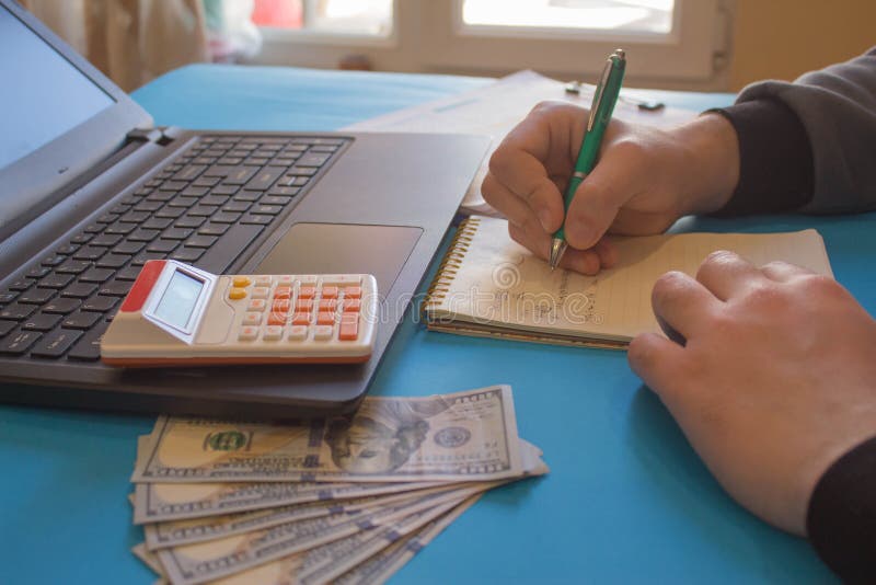 Man Writing Notes from Computer on Wooden Table. Man Hand with Pen ...