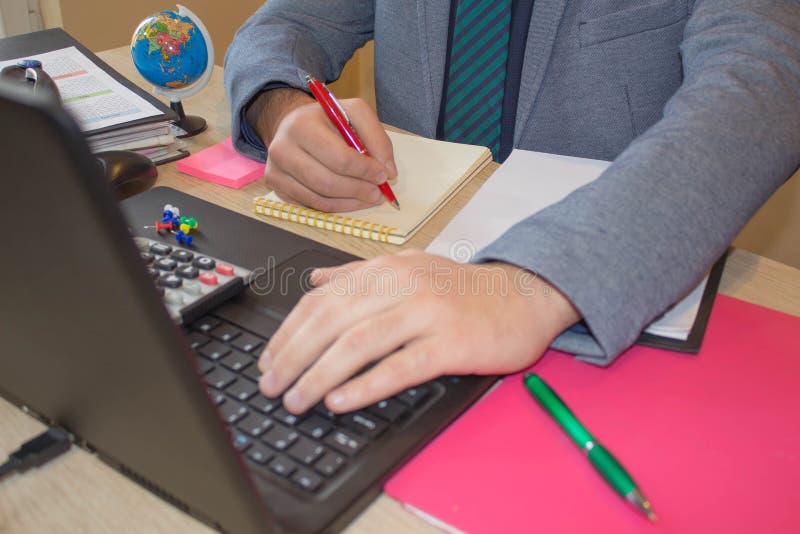 Man Writing Notes from Computer on Wooden Table. Man Hand with Pen ...