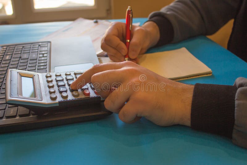 Man Writing Notes from Computer on Wooden Table. Man Hand with Pen ...