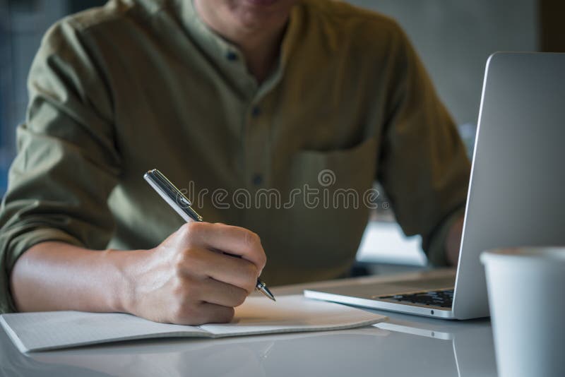 Man Writing Notes with a Laptop at Desk. Online Education and E ...