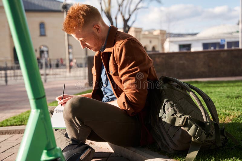 Man Writing Notes while Sitting at the Street Outdoors during the Great ...