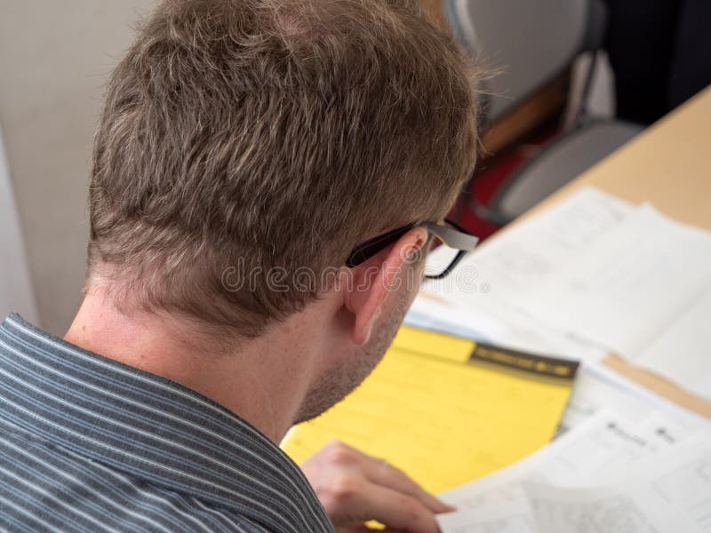 A Man Writing Up Paperwork at Work. Stock Image - Image of smile ...
