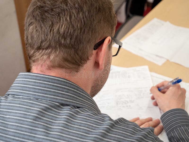 A Man Writing Up Paperwork at Work. Stock Image - Image of smiling ...