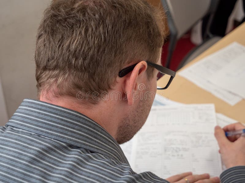 A Man Writing Up Paperwork at Work. Stock Photo - Image of paper ...