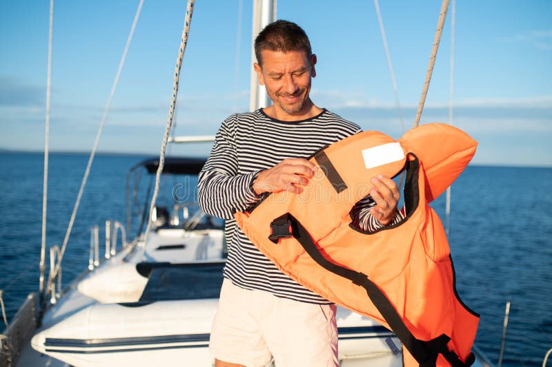 Man on a Yacht Putting on a Life Jacket Stock Image - Image of harmony ...