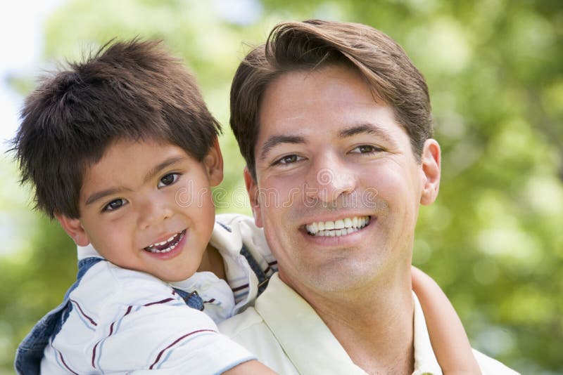 Man and Young Boy Embracing Outdoors Smiling Stock Image - Image of ...