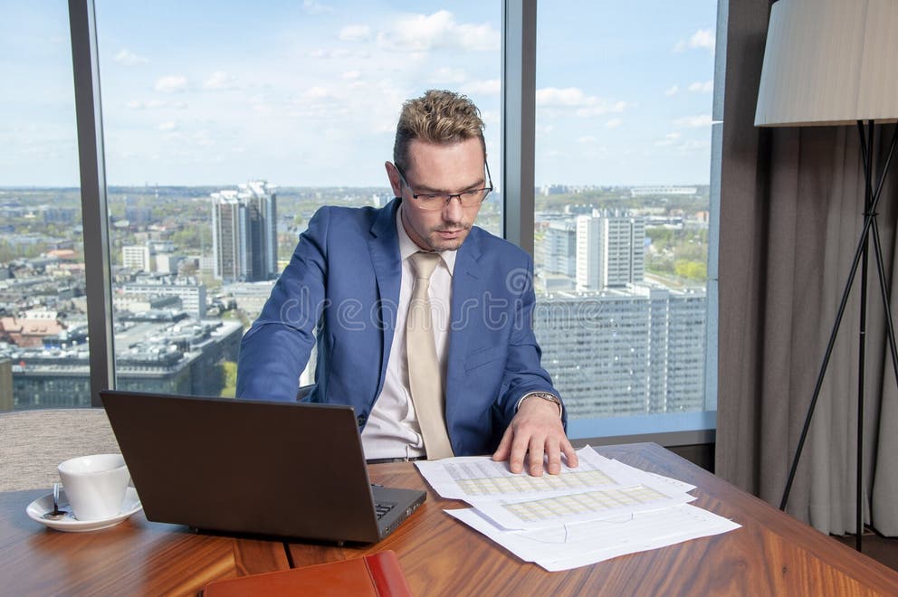 The Manager Behind the Desk in the Office Hard Work on the Data. Stock ...