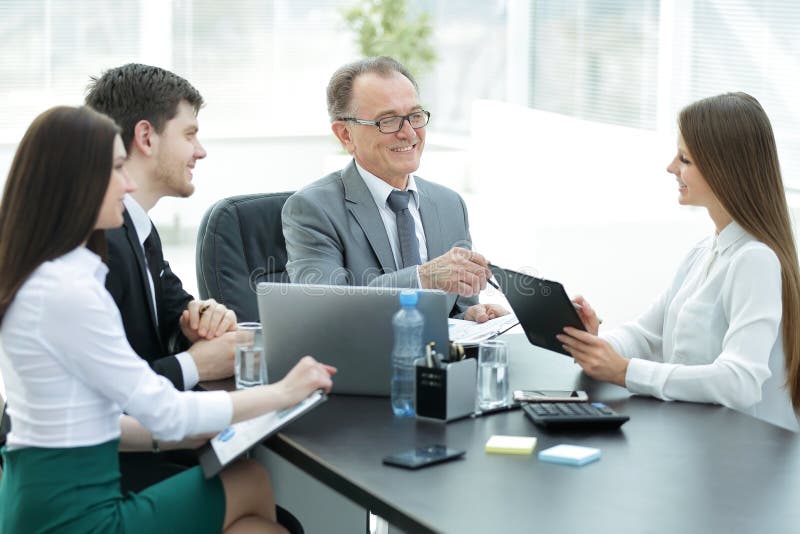 Manager Discussing Work Issues with His Assistants Behind a Desk Stock ... Manager Discussing Work Issues with His Assistants Behind a Desk Stock ...