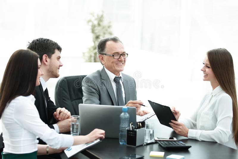 Manager Discussing Work Issues with His Assistants Behind a Desk Stock ...