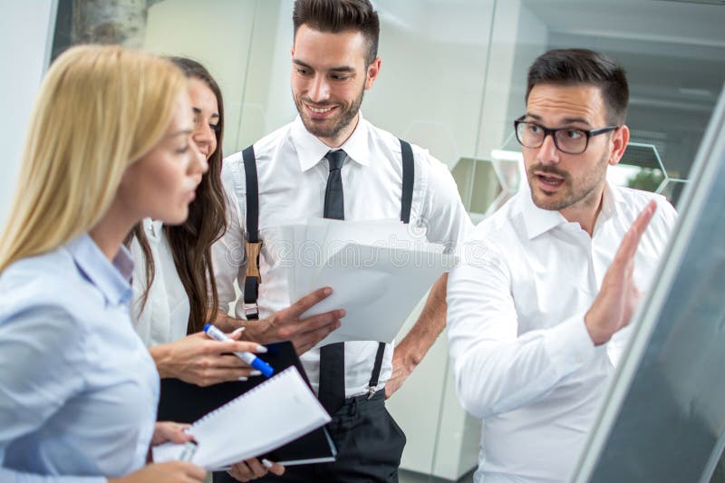 Manager Explaining Something Over Flip Chart To Coworkers in Modern ...