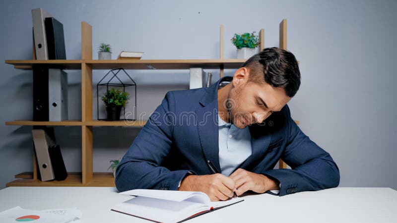 Manager in Formal Wear Writing on Notebook at Table in Office. Stock ...