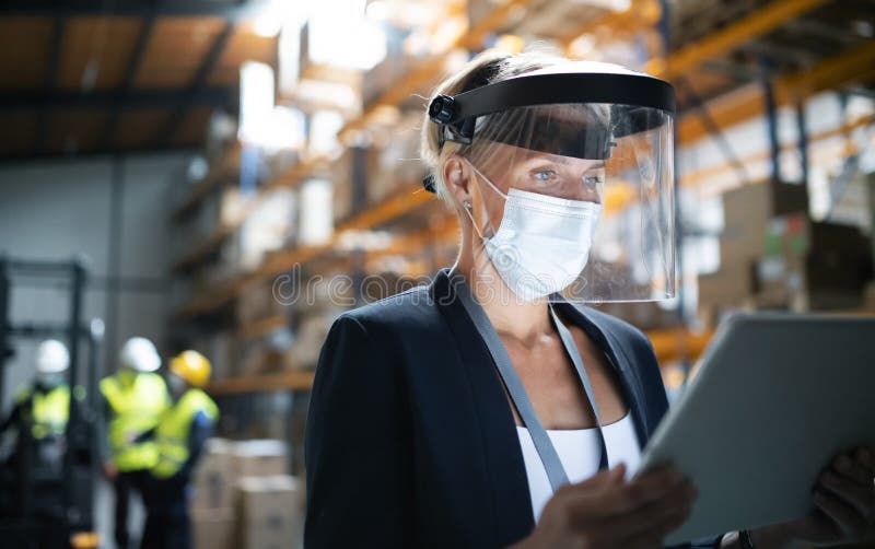Manager with Protective Shield Uisng Tablet Indoors in Warehouse ...
