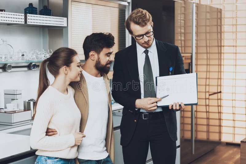 A Salesman in a Suit Shows Buyers the Layout. Stock Photo - Image of ...