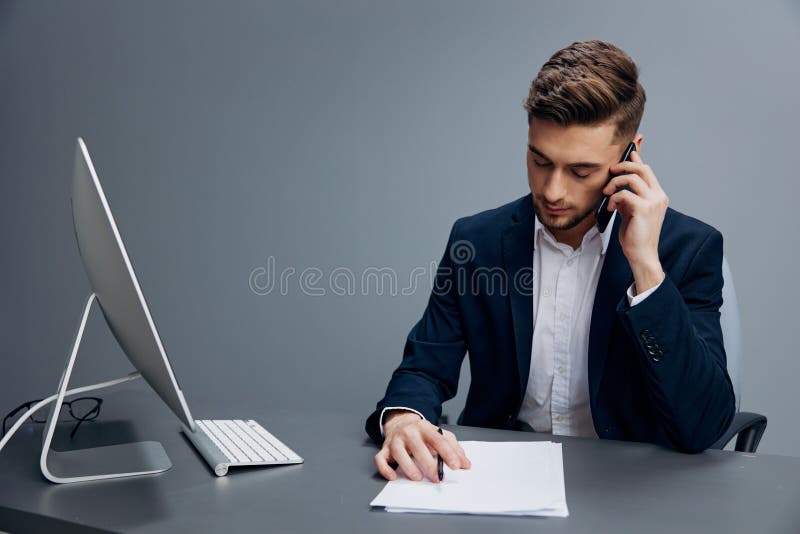 Manager Sitting at a Desk in Front of a Computer with Phone ...