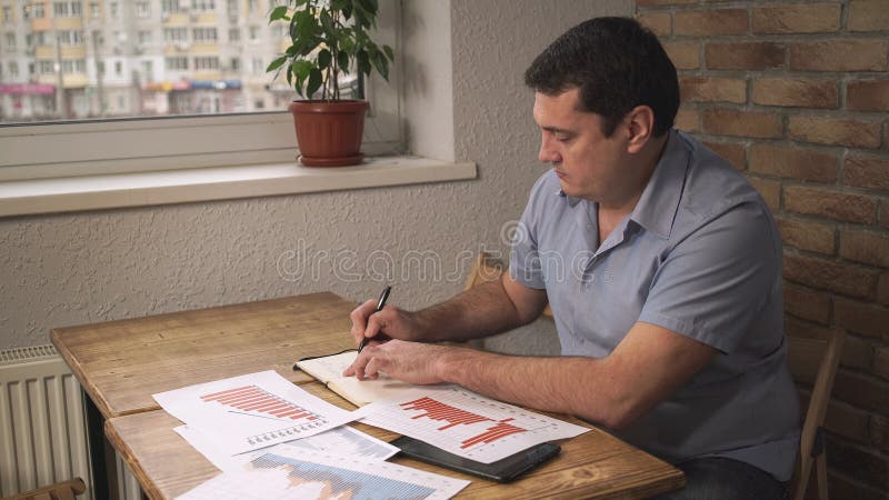 Manager Sitting at Desk, Taking Notes in a Notebook, on a Table ...