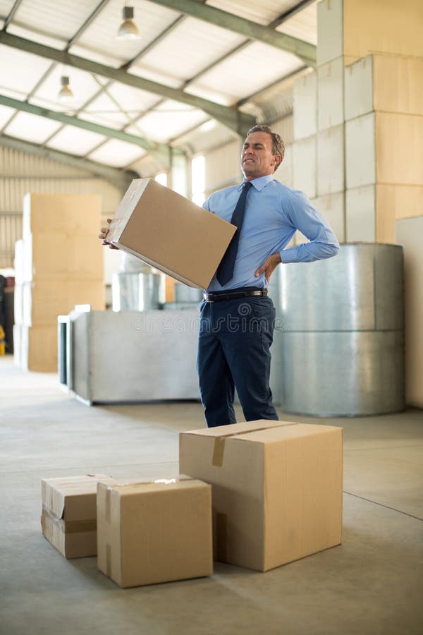 Manager Suffering from Back Pain while Holding Heavy Box Stock Photo ...