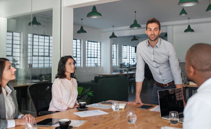 Manager Talking with His Staff Around an Office Table Stock Photo ...