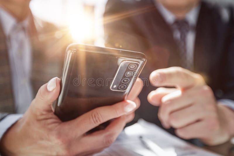 Manager Uses Smartphone while Sitting at Table with Colleague Stock ...