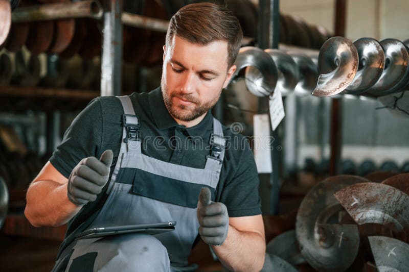 Manager is Using Digital Tablet. Man in Uniform is in Workstation ...