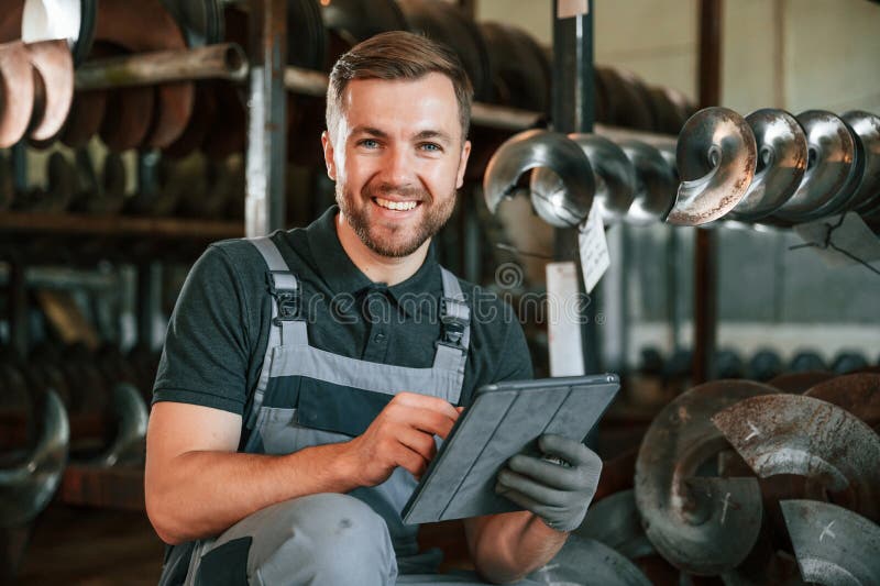 Manager is Using Digital Tablet. Man in Uniform is in Workstation ...