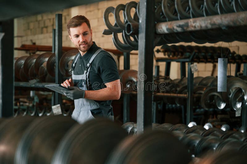Manager is Using Digital Tablet. Man in Uniform is in Workstation ...