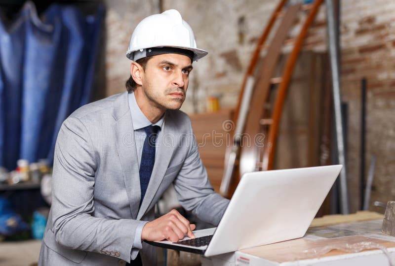 Manager Using Laptop with Blueprints Stock Photo - Image of computer ...