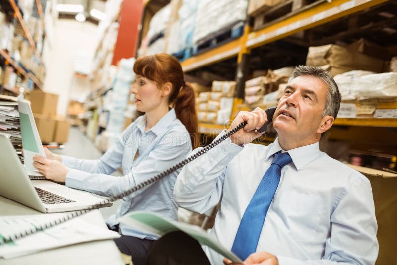 Manager Working on Laptop and Talking on Phone at Desk Stock Photo ...