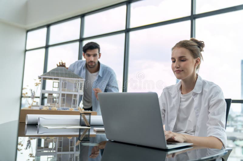 Manager Working by Using Laptop while Engineer Inspect House Model ...