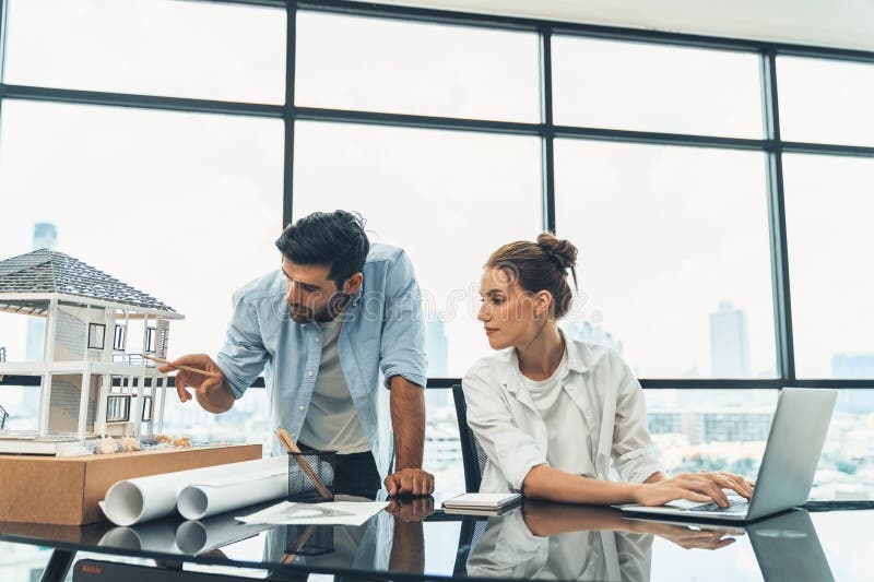 Manager Working by Using Laptop while Engineer Inspect House Model ...