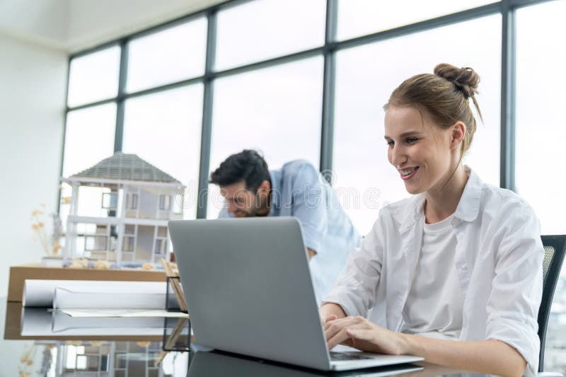 Manager Working by Using Laptop while Engineer Inspect House Model ...