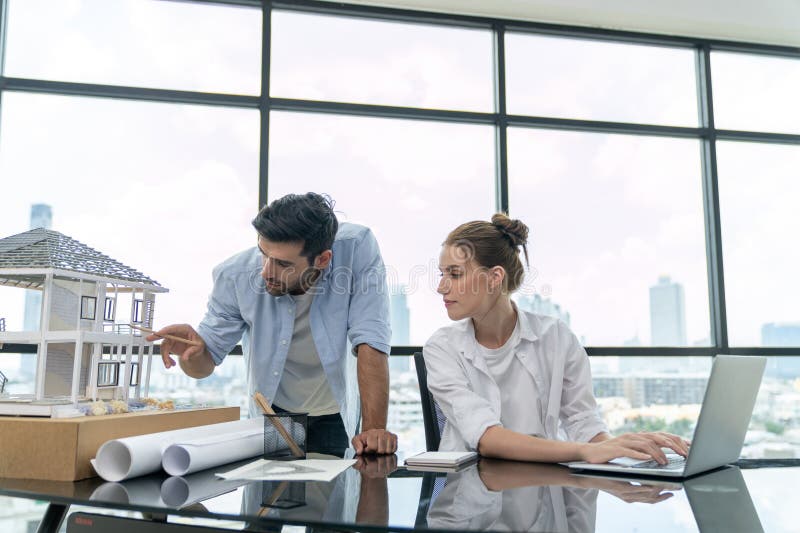 Manager Working by Using Laptop while Engineer Inspect House Model ...