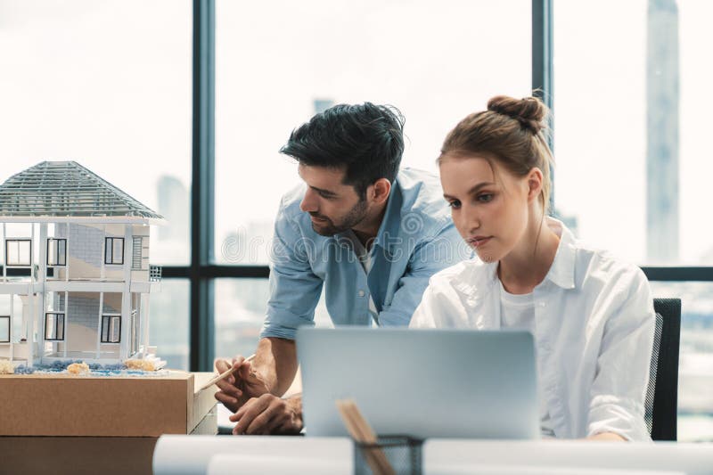 Manager Working by Using Laptop while Engineer Inspect House Model ...