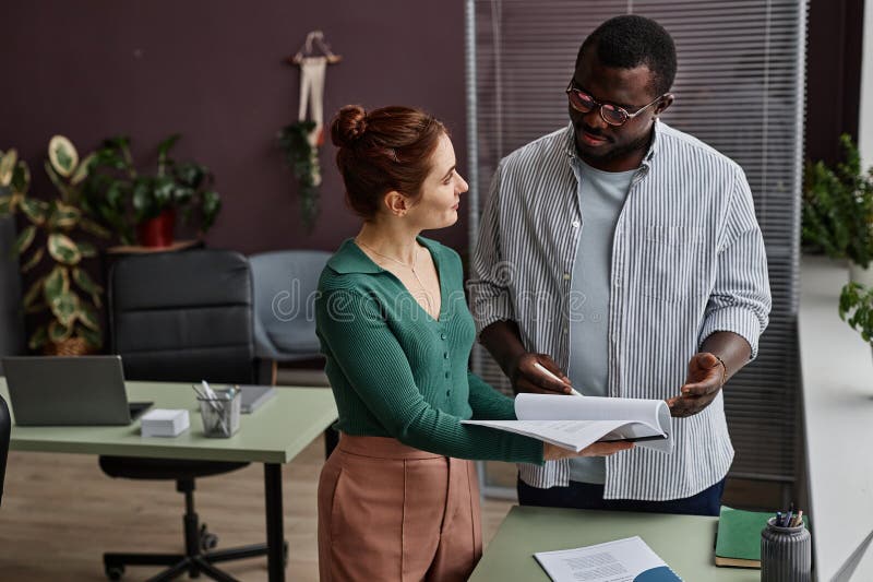 Manager Working with Young Employee and Discussing Documents in Office ...
