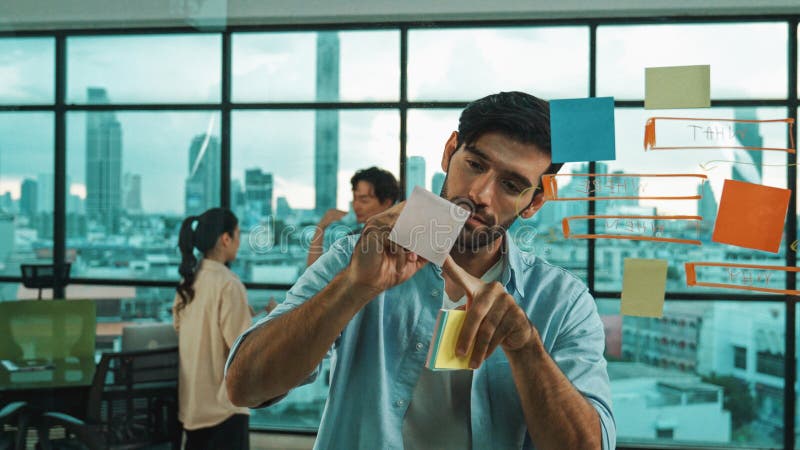 Manager Writing Sticky Notes at Glass Wall To Planing Strategy. Tracery ...