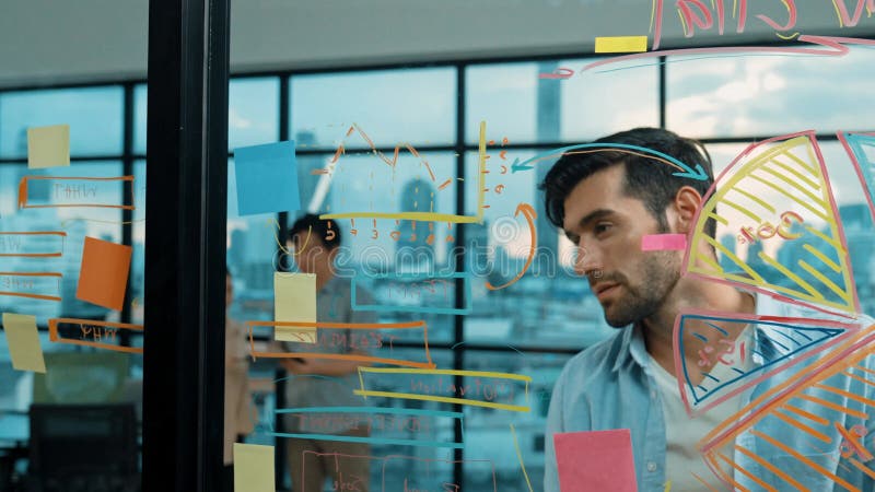 Manager Writing Sticky Notes at Glass Wall To Planning Strategy ...