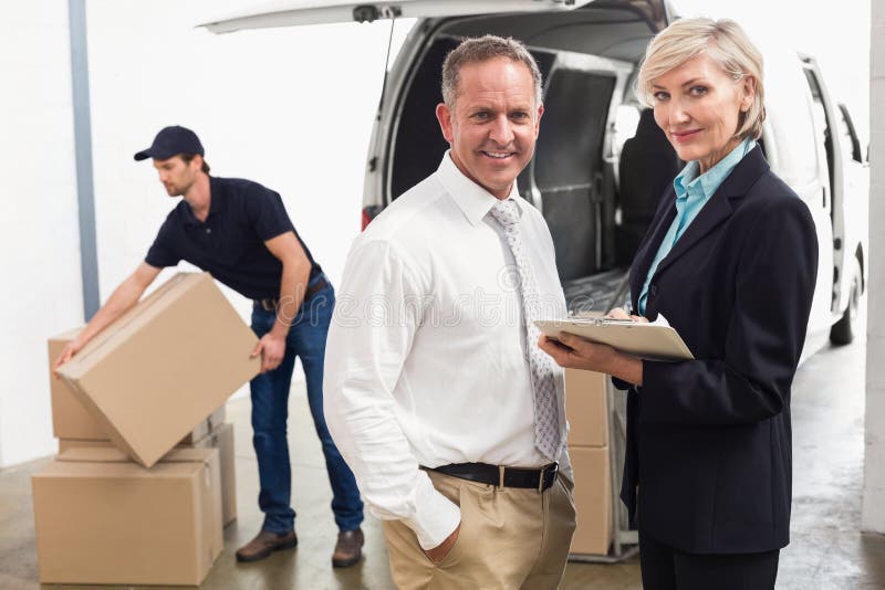 Managers Smiling at Camera with Delivery Driver Behind Stock Photo ...