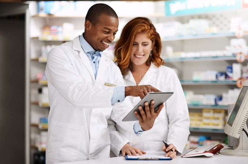 Managing Tasks the Digital Way. Two Pharmacists Working Together on a ...