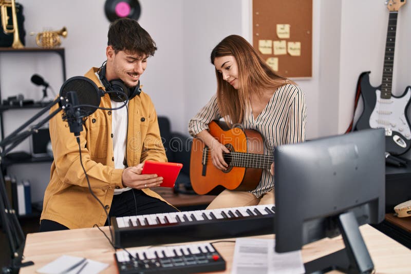 Mand and Woman Musicians Playing Classical Guitar Using Touchpad at ...