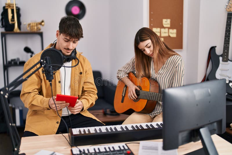 Mand and Woman Musicians Playing Classical Guitar Using Touchpad at ...
