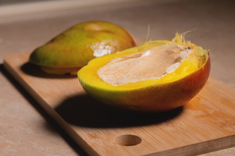 Mango. Close-up of Fresh Mango Fruit Cut in Half on Wooden Cutting ...