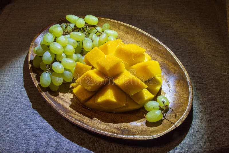 Mango and Grapes on a Wooden Plate Stock Photo - Image of vegetarian ...