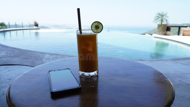 Mango Juice with a Lime Wedge and a Swimming Pool As a Background Stock ...
