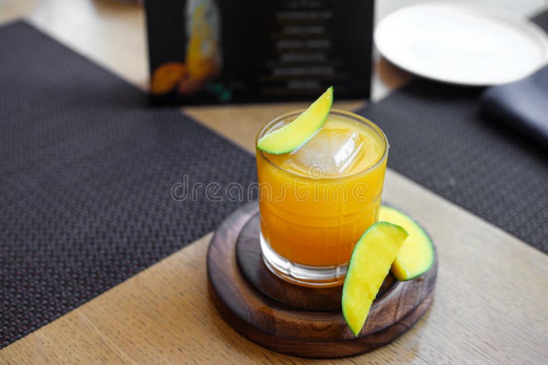 Mango Juice on Restaurant Table with Raw Mango Slice on Side Stock ...