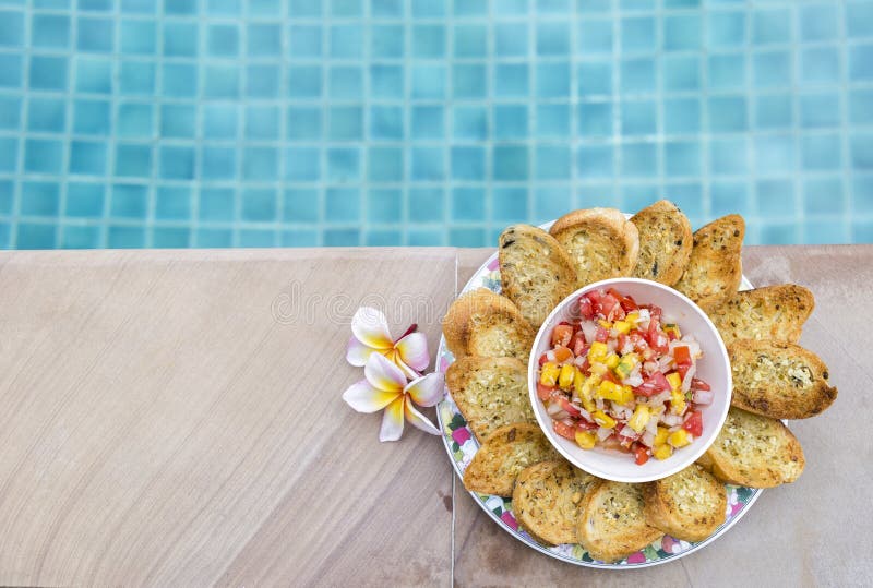 Mango Salsa with Garlic Bread with Space on Swimming Pool Edge ...