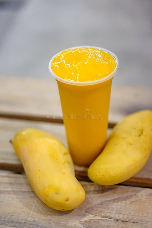 A Mango Smoothie Ready To Drink, Decorate with Mango beside Stock Image ...
