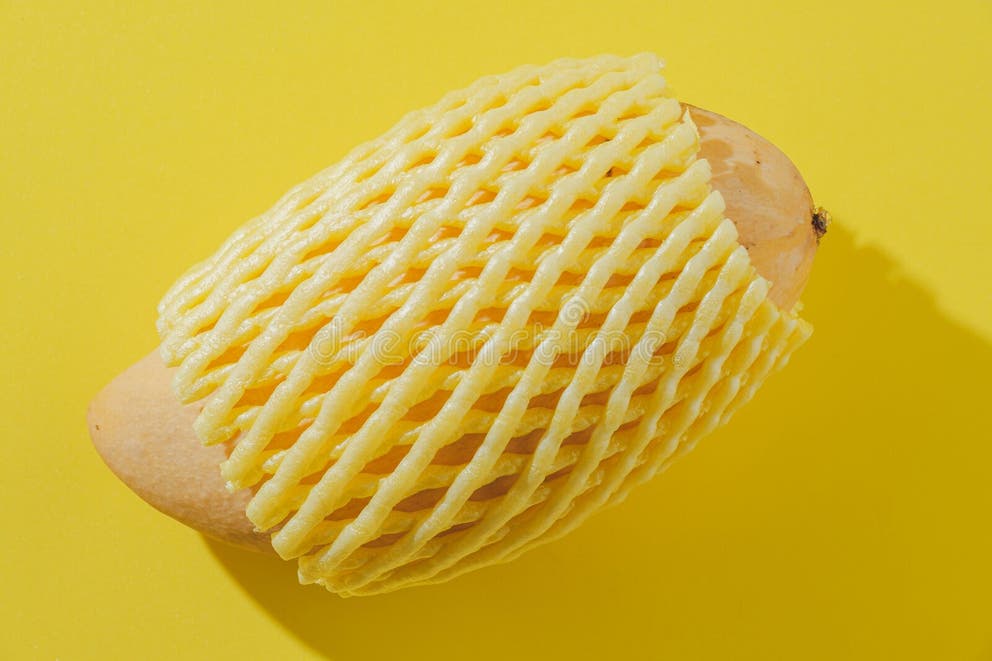 Mango Wrapped in Foam Net on a Yellow Background Stock Image - Image of ...