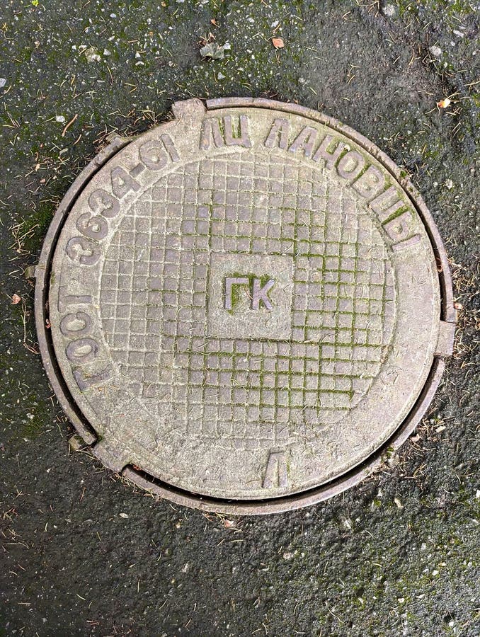 A Manhole Cover on the Ground with a Grid Pattern on it Stock Photo ...